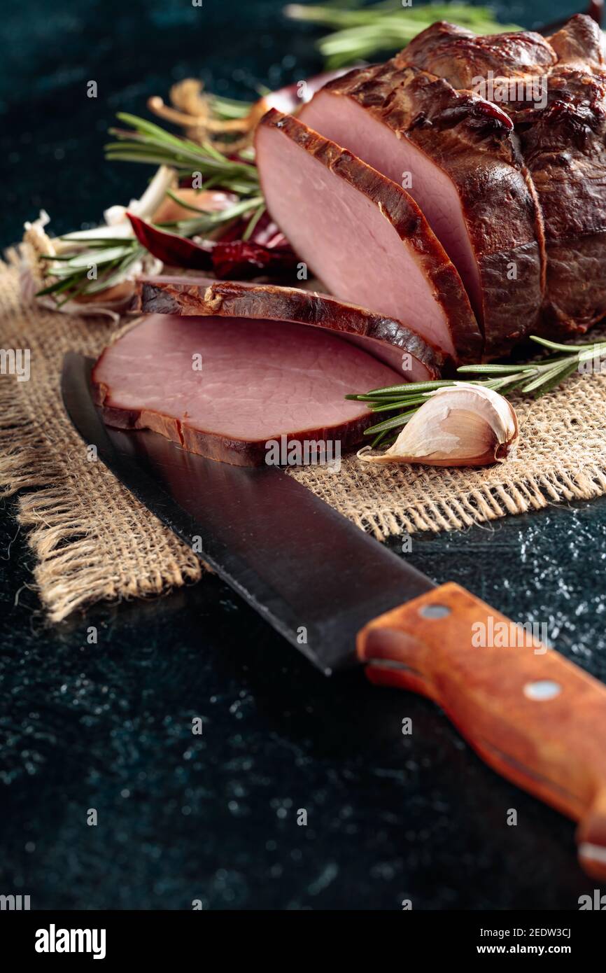Smoked ham with rosemary, garlic, and pepper on a kitchen table Stock ...