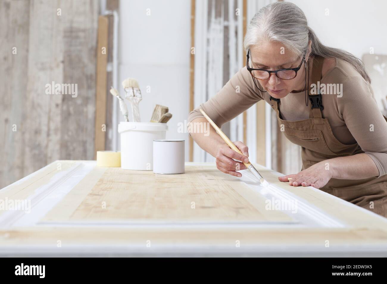 wood crafts, woman artisan carpenter painting with brush and paint jar ...