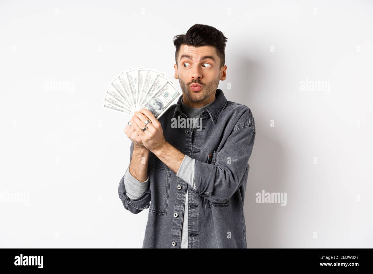 Excited man hugging and kissing dollar bills, holding money and ...