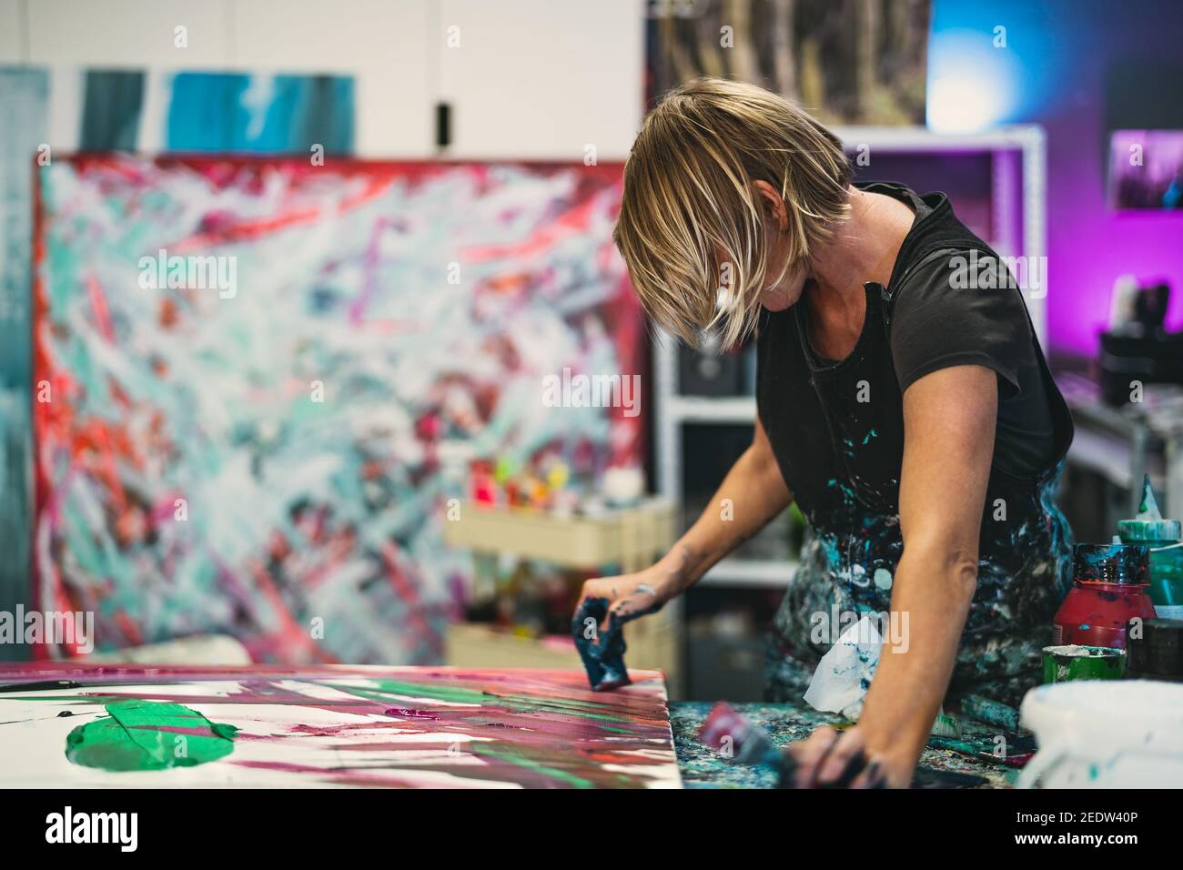 Woman artist painting on canvas in workshop studio - Painter work and ...