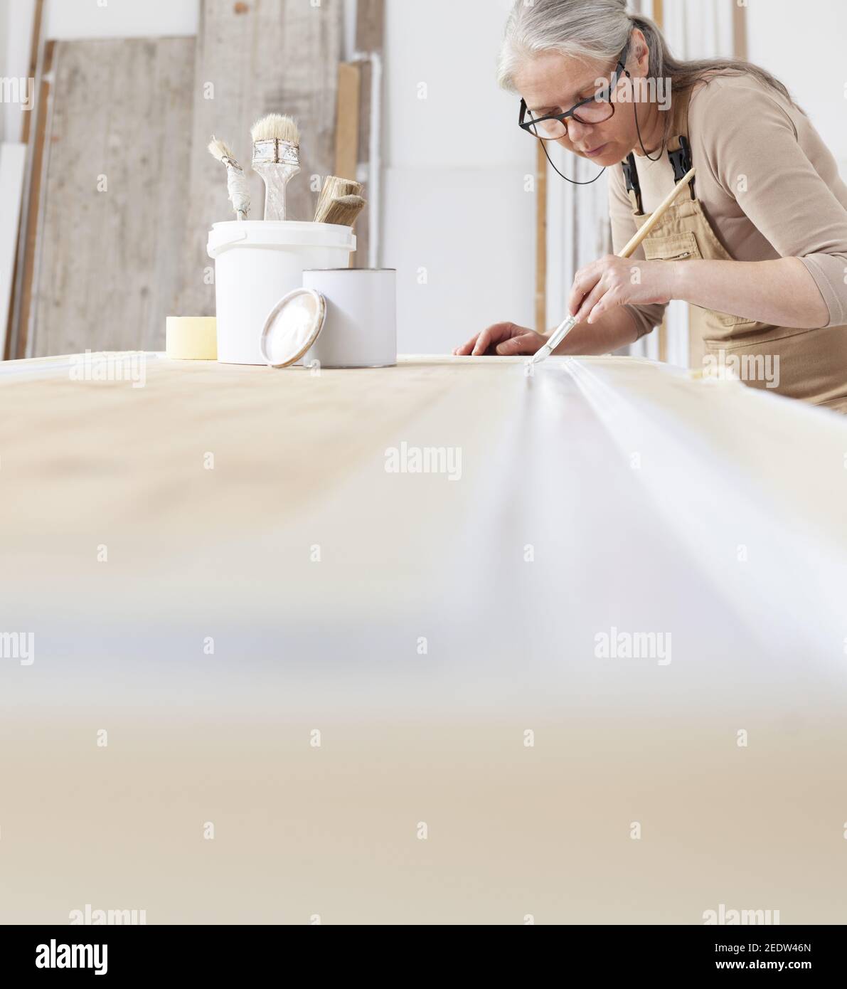 wood crafts, woman artisan carpenter painting with brush and paint jar ...