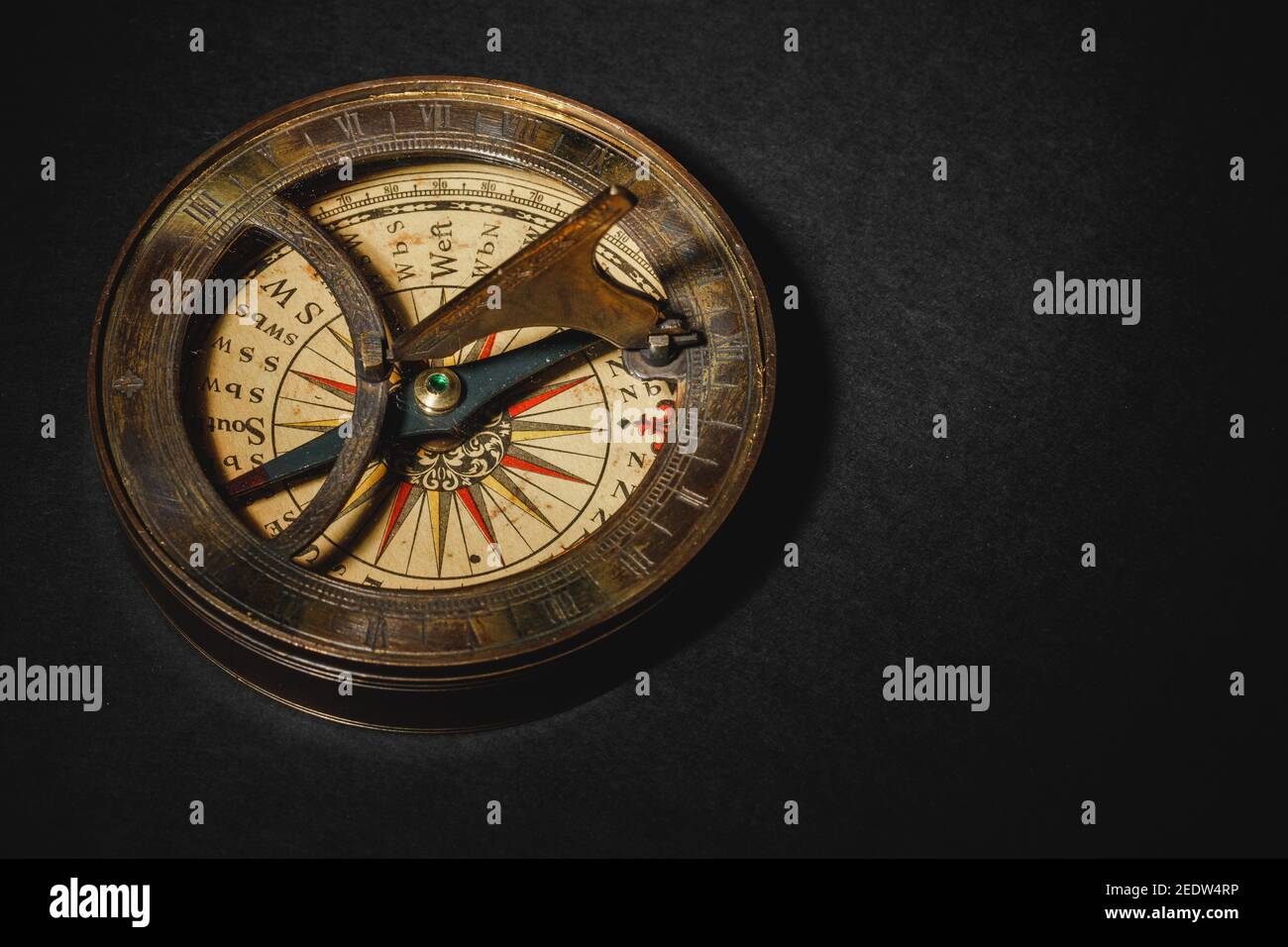 Retro compass on black board background. Close up Stock Photo - Alamy