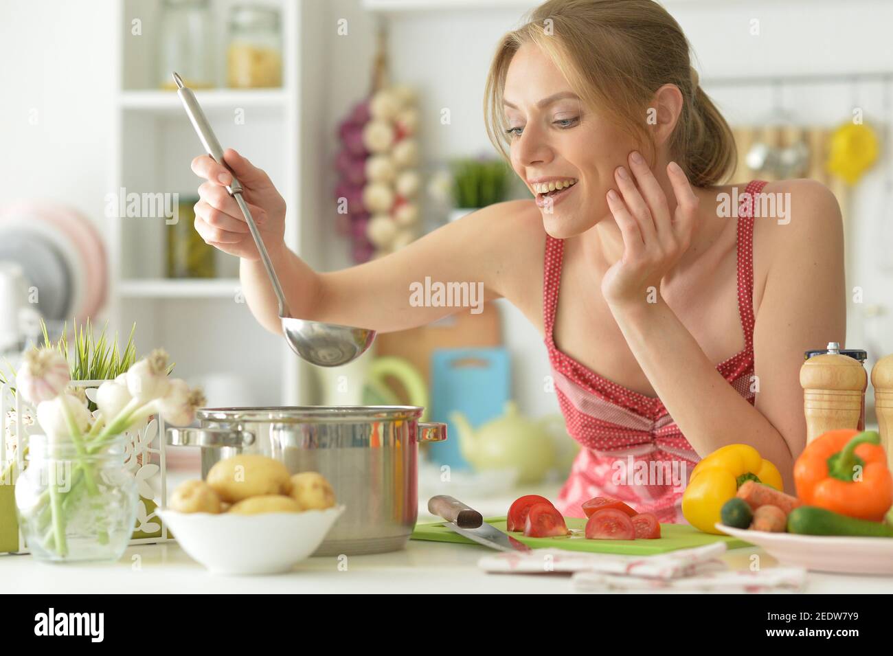 Beautiful young woman cooking soup in kitchen Stock Photo - Alamy