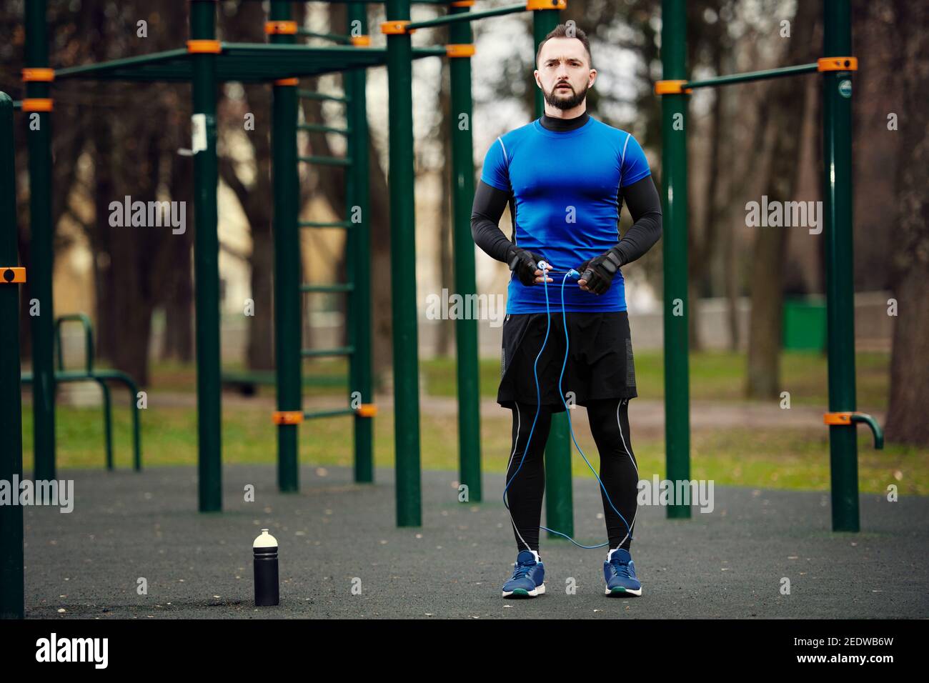 Young strong man with a rope on a sports field in the summer Stock ...