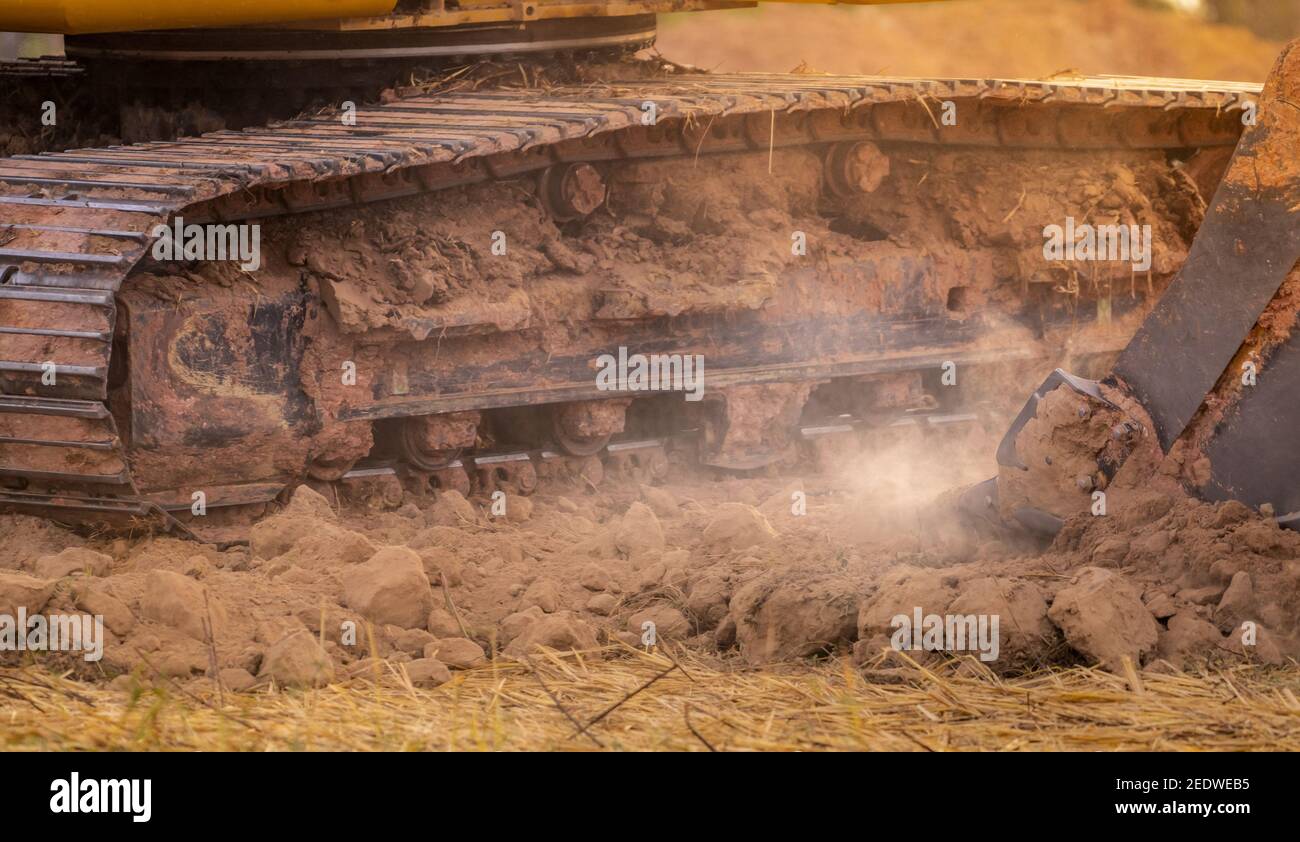 Backhoe working by digging soil at construction site. Bucket teeth of ...
