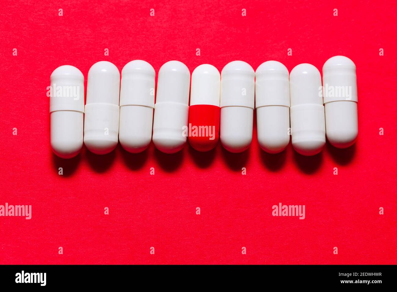 White capsule pills at red background . Prescription medications drug ...