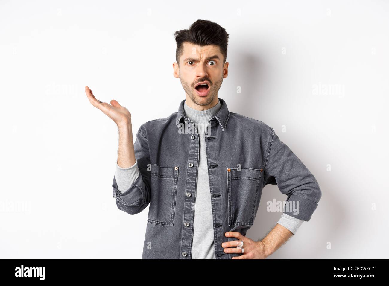 Confused and annoyed guy raising hand up and complaining, asking wtf ...