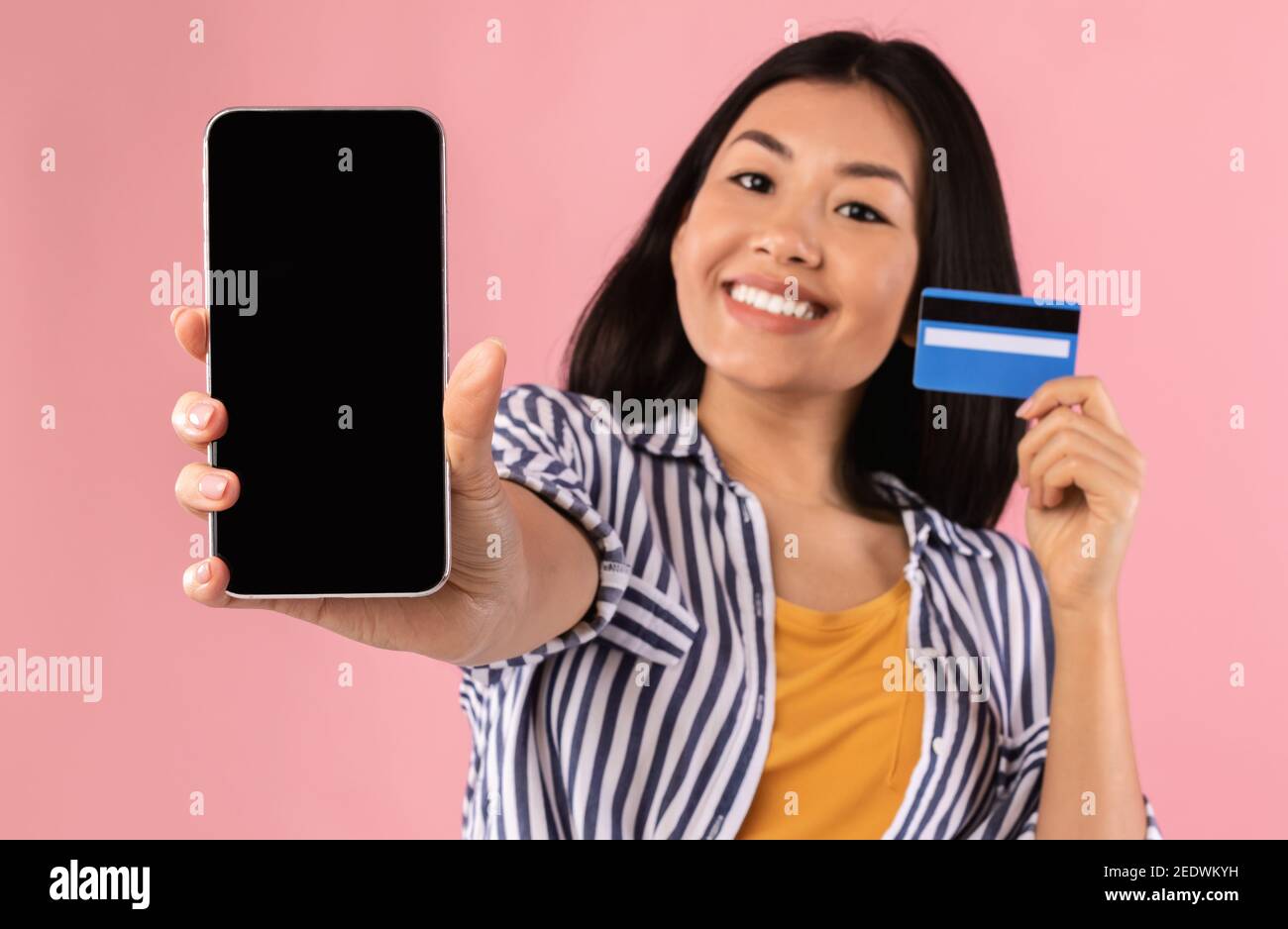Asian lady showing blank smartphone screen and credit card Stock Photo ...