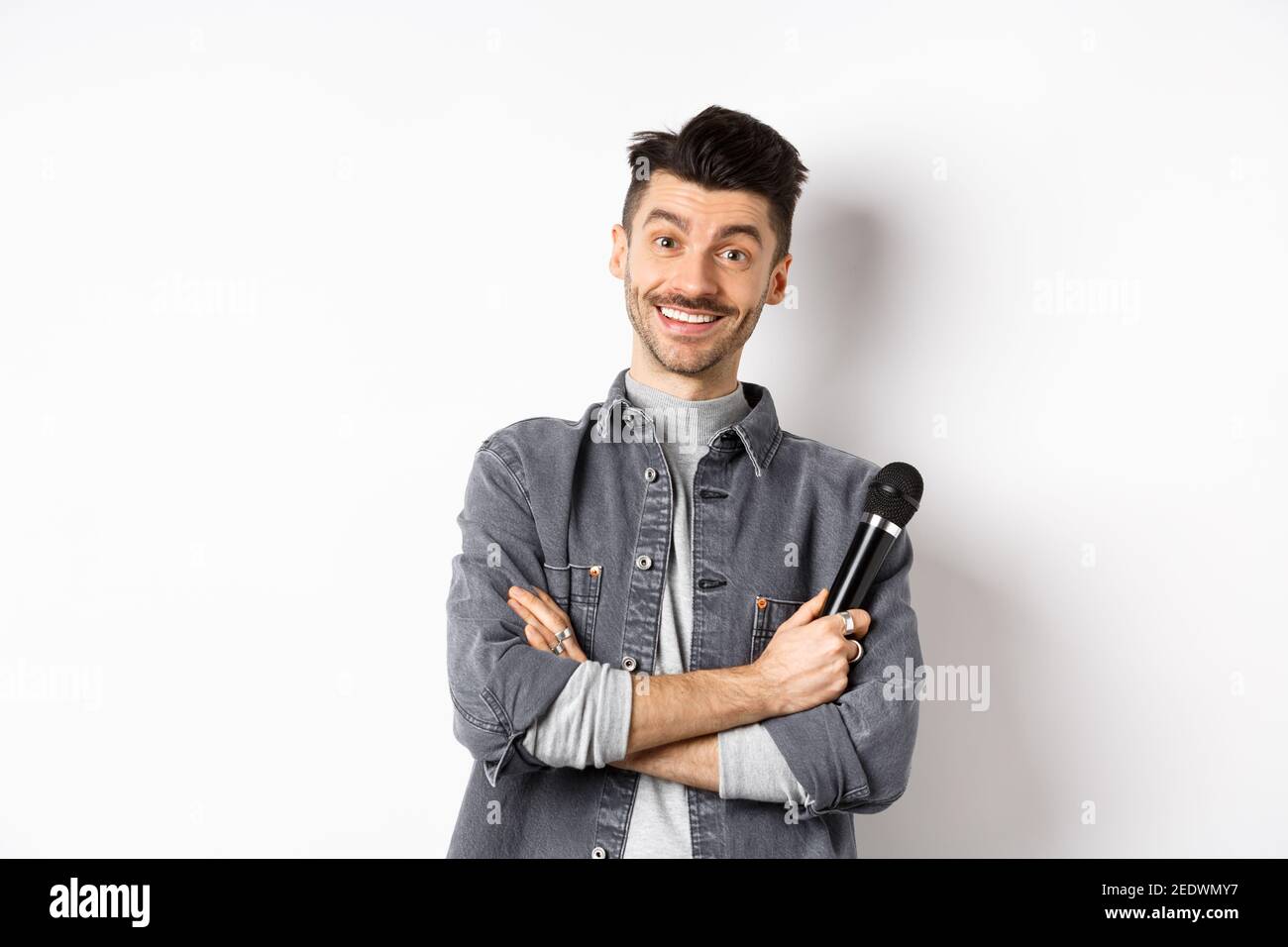 Handsome caucasian guy with moustache cross arms on chest, holding mic ...