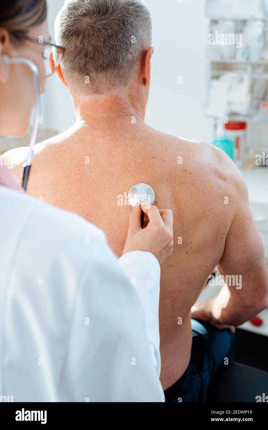 Doctor using stethoscope to check lung function of man Stock Photo - Alamy