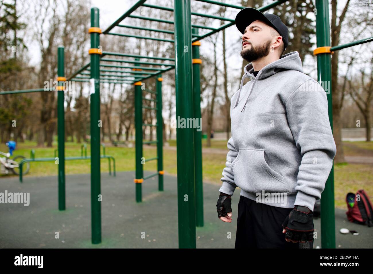 Young strong man prepares for training on a sports field in the summer ...