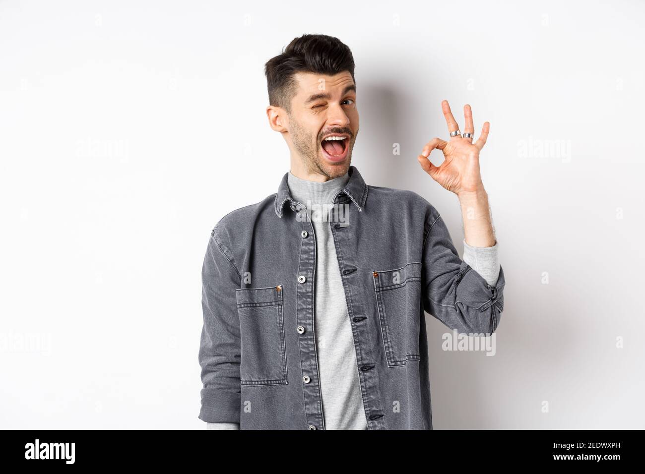 Excited handsome guy with moustache, winking and showing okay sign ...