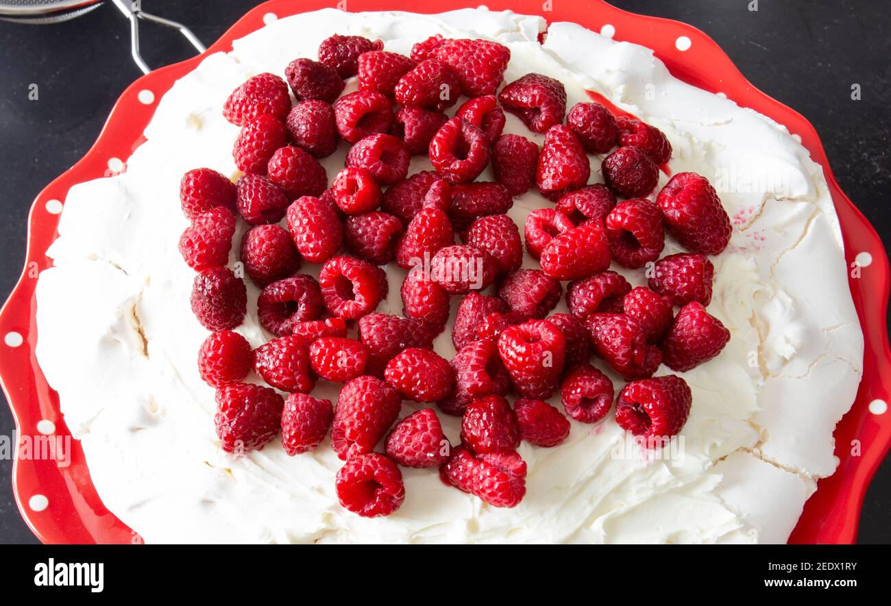 Pavlova, meringue cake preparation. Fresh frozen raspberry top view ...