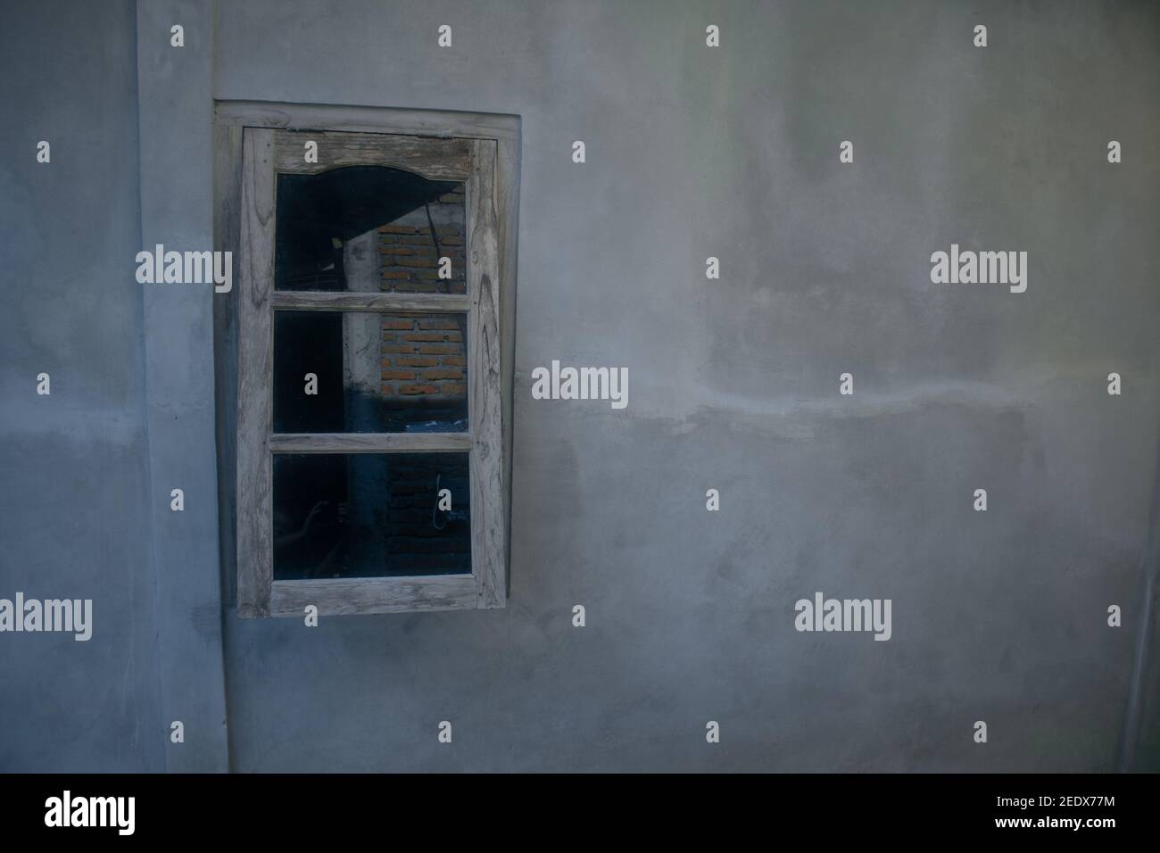 Half open wooden window on ultimate grey plastered wall background ...