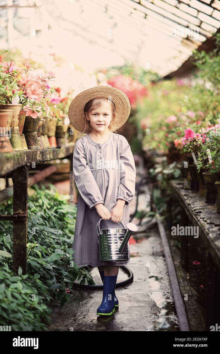 Child planting spring flowers. Little girl gardener plants azalea. Girl ...