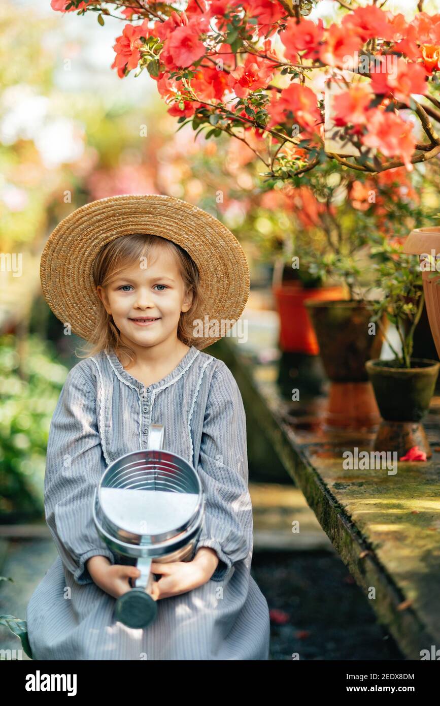Child planting spring flowers. Little girl gardener plants azalea. Girl ...