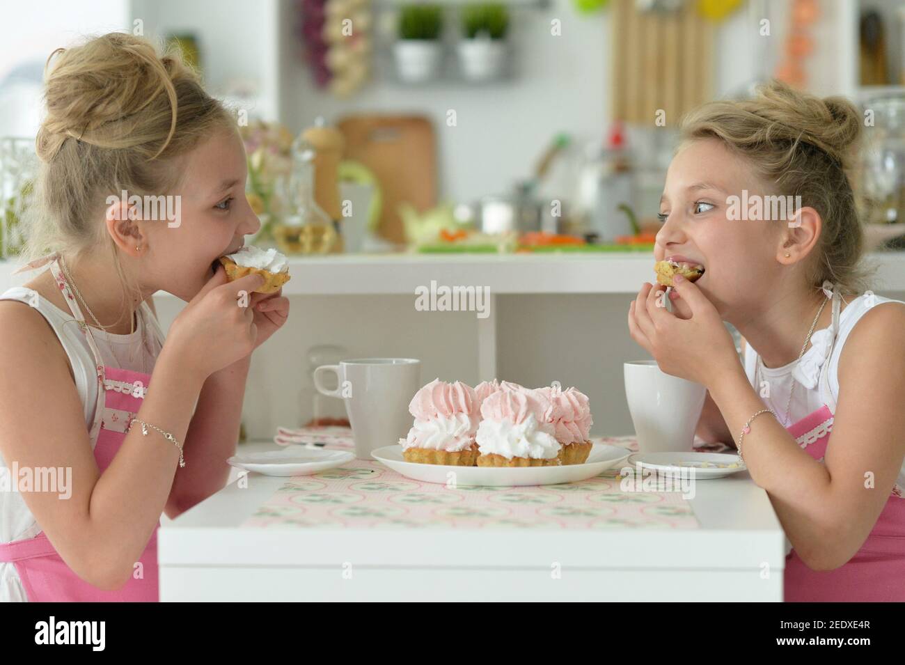 Portrait of girls eating cakes at home Stock Photo - Alamy