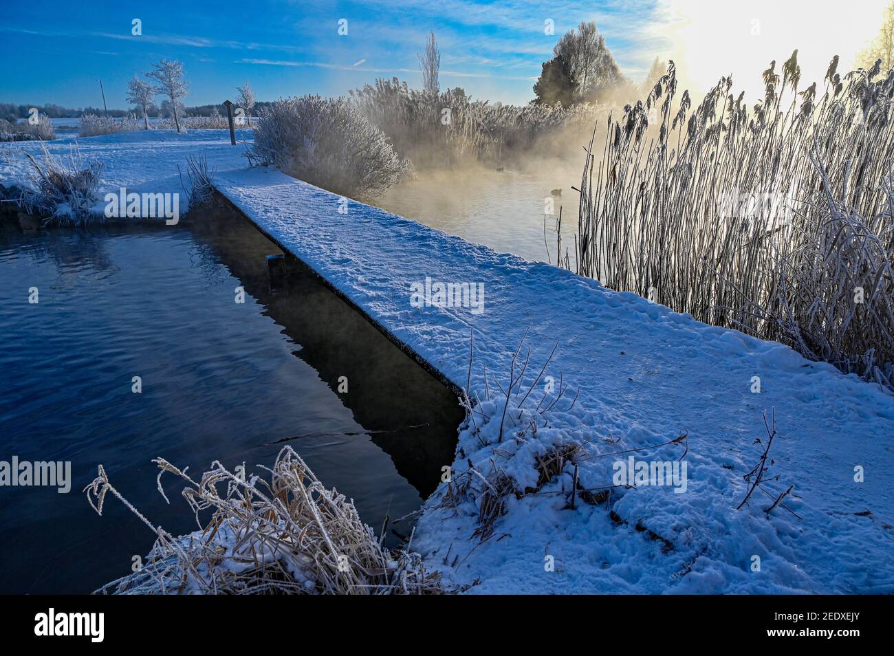 jetty over water in pond covered in snow Stock Photo - Alamy