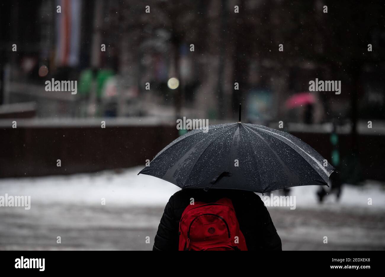 Duesseldorf, Germany. 15th Feb, 2021. A man with an umbrella walks ...