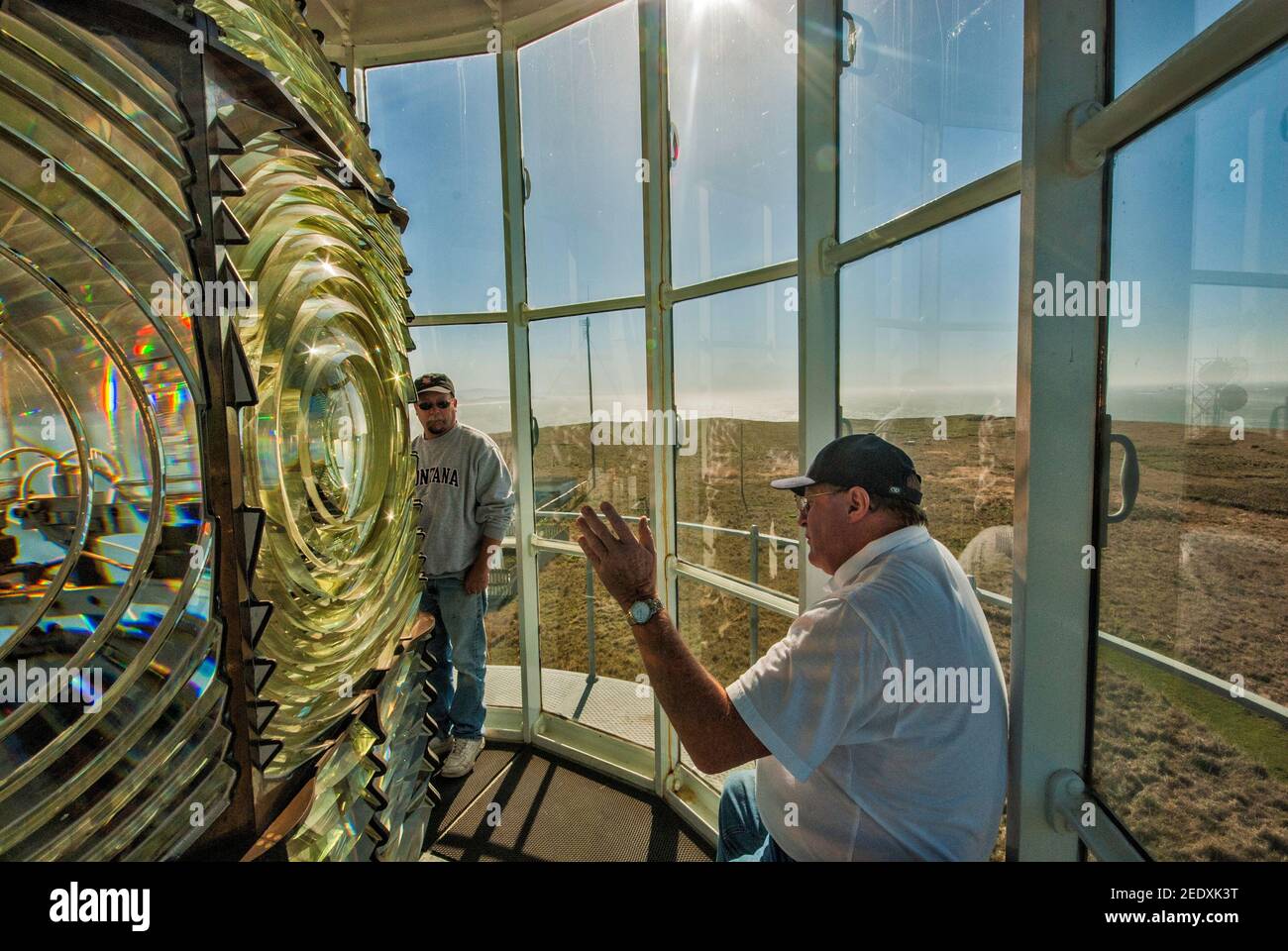 Fresnel lens, interpreter and visitor at Cape Blanco Lighthouse near Port Orford, Oregon, USA ...