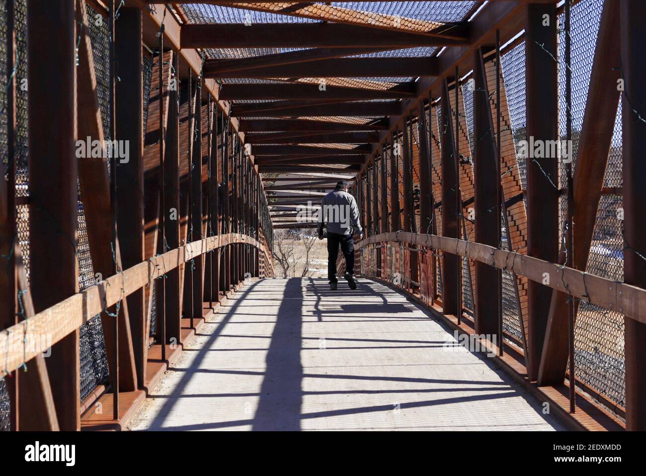 Back view of a male walking on a bridge Stock Photo - Alamy