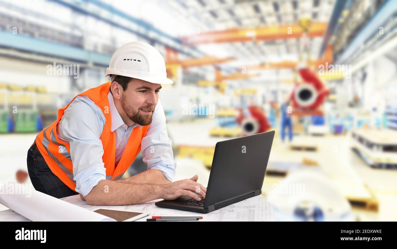 engineer at his workplace with notebook in an industrial company in ...