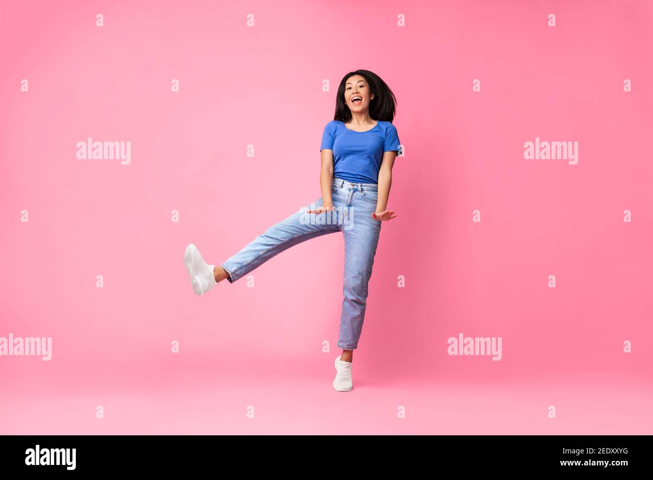 Happy young asian lady jumping at studio Stock Photo - Alamy