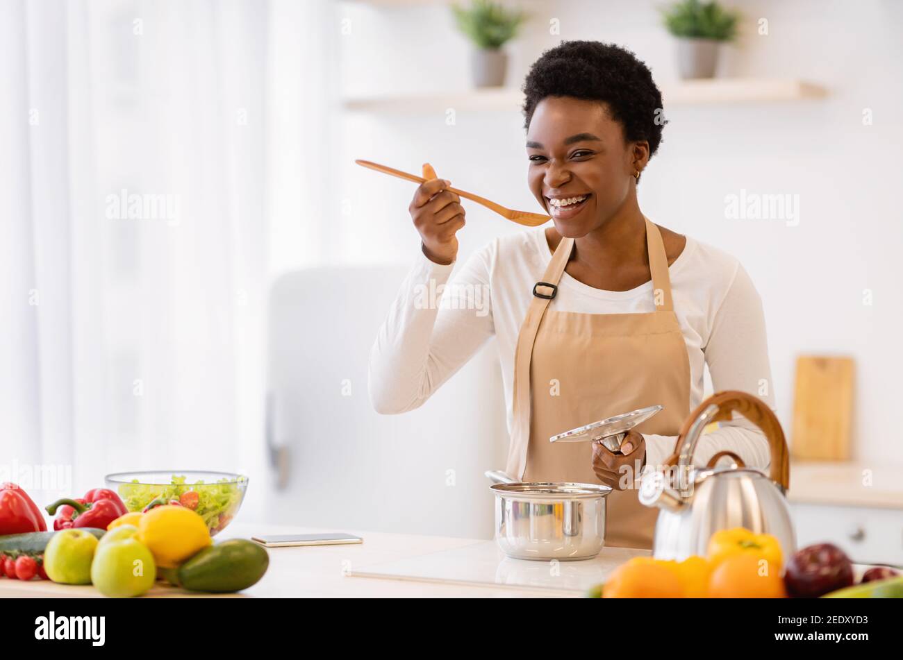 Happy African American Woman Cooking Tasting Dinner In Kitchen Indoor ...