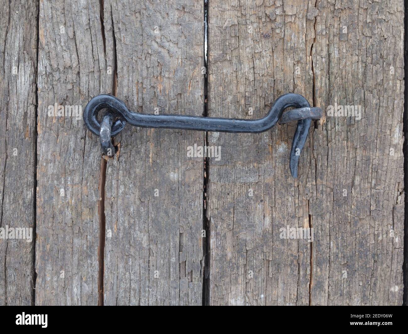 Black metal hook on a wooden door made from old spruce boards Stock ...