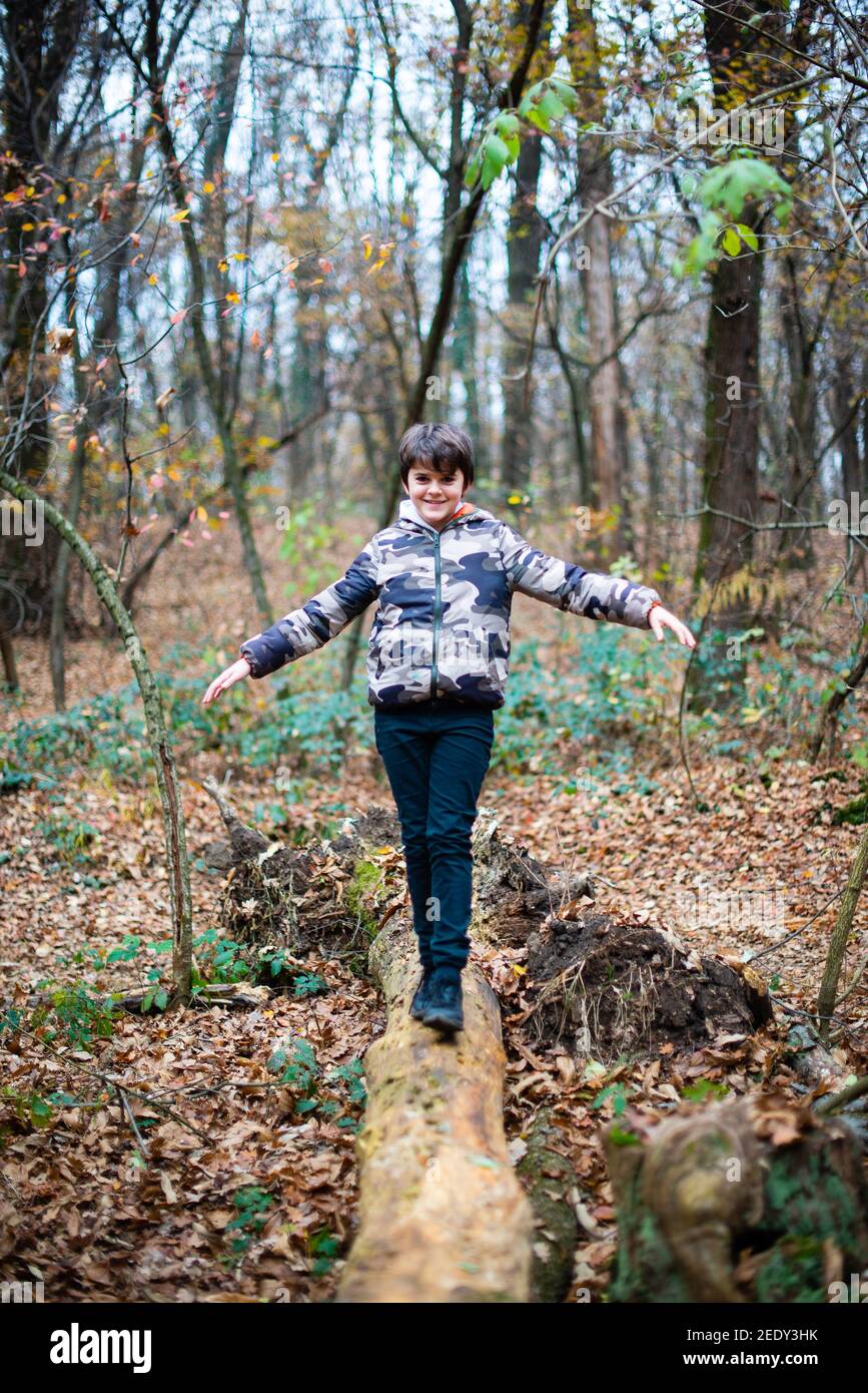 smiling child walks on fallen tree in balance Stock Photo - Alamy