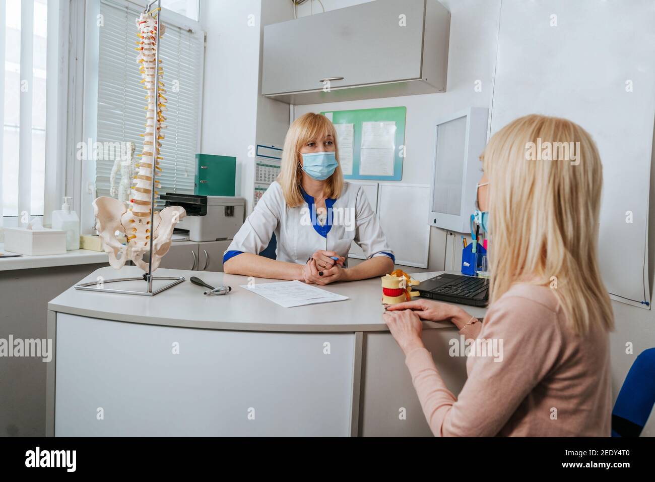 Female patient talking to doctor about her problems with her back ...