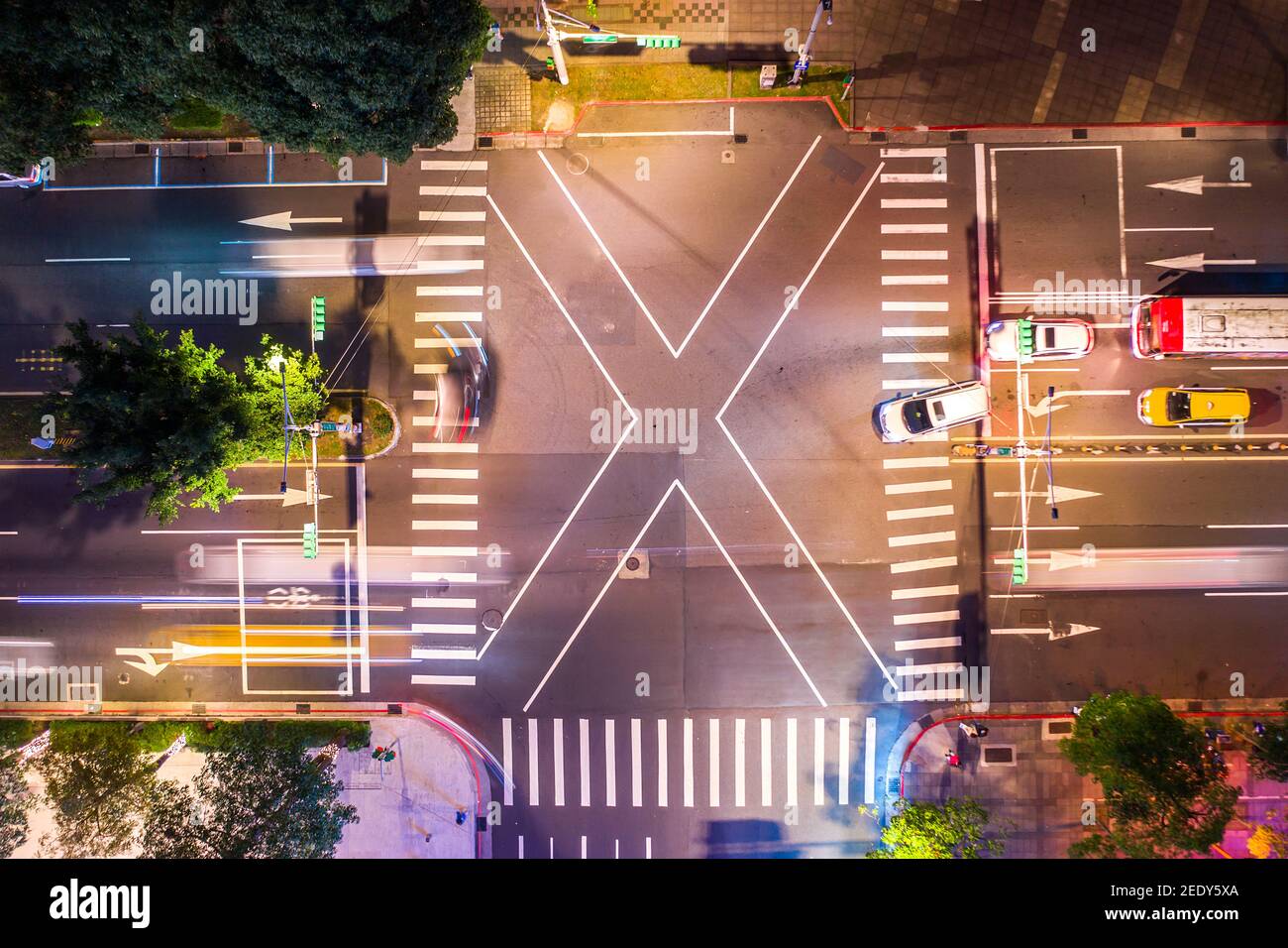 Car, taxi, and bus traffic on road intersection at night Stock Photo ...