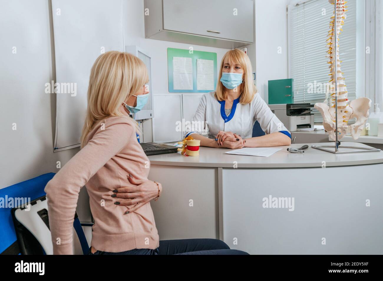 Female patient talking to doctor about her problems with her back ...