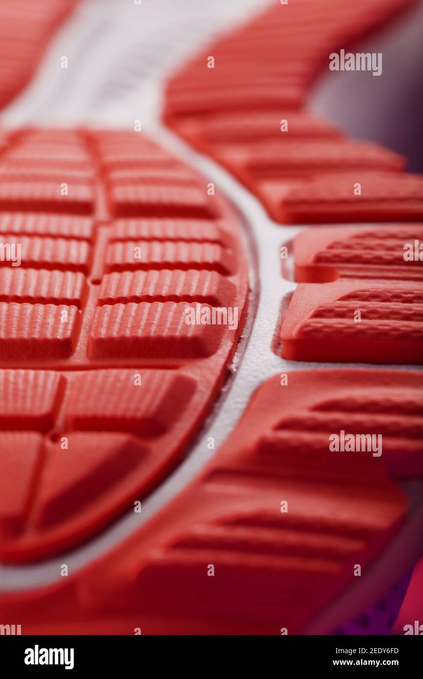 Textured design of the sole of the sport shoe in red Macro. Close-up ...