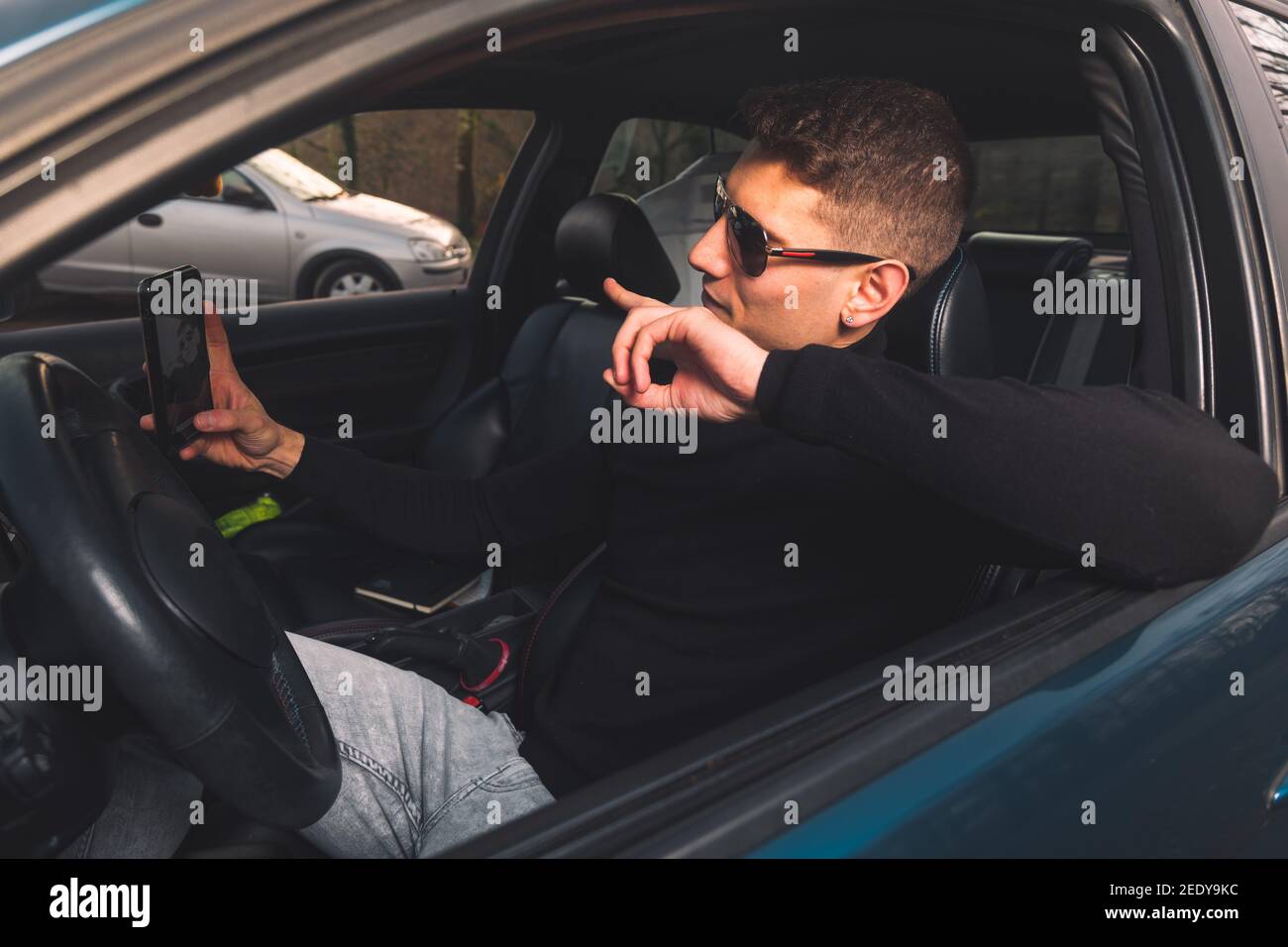 Young caucasian man inside a car using a smartphone Stock Photo - Alamy