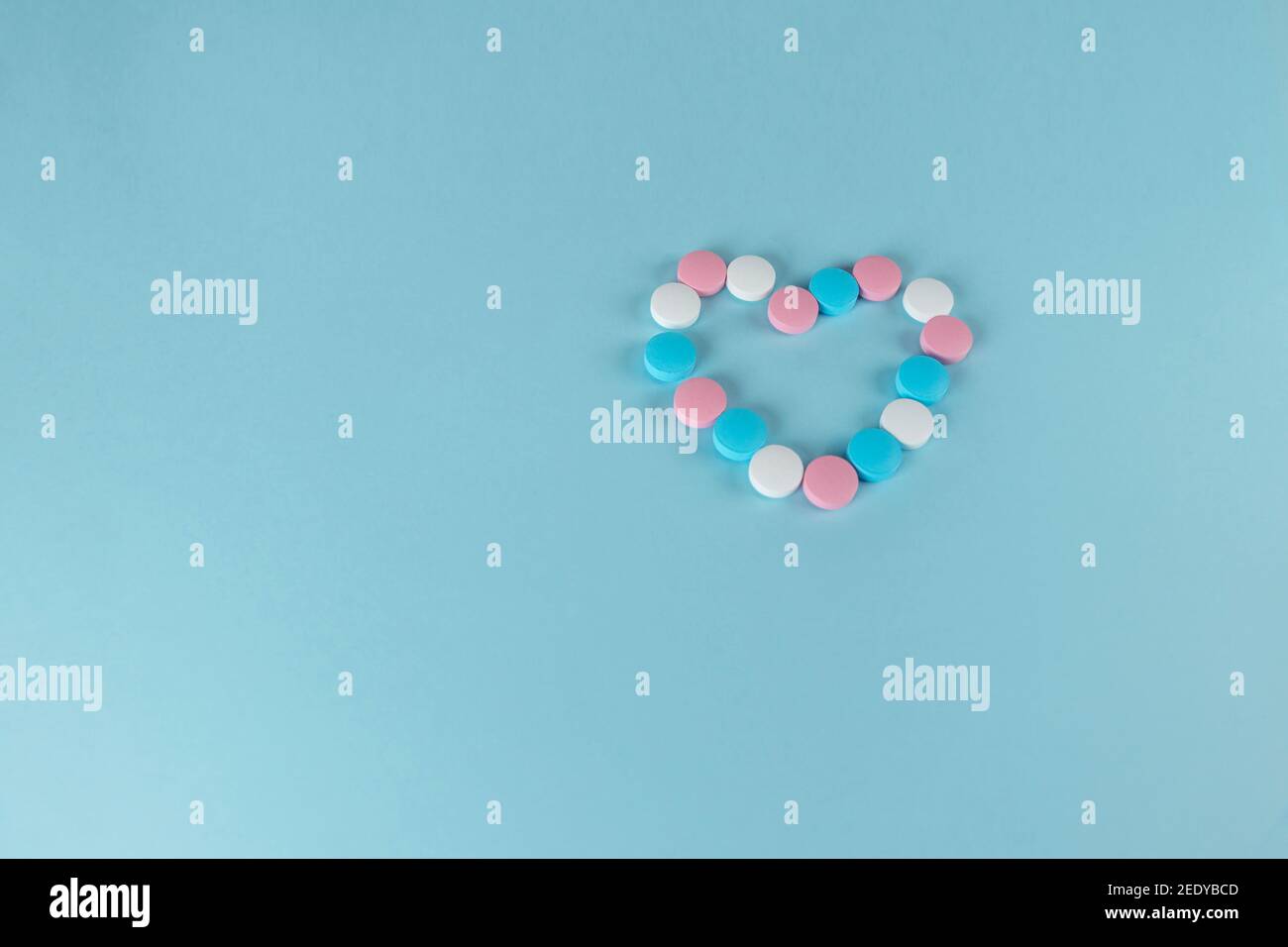 Medicines and pills. Heart-shaped blue, pink and white pills ...