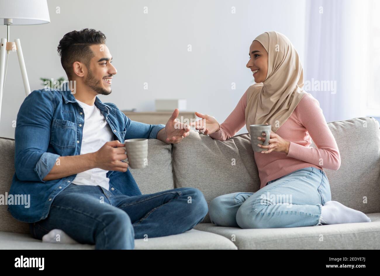 Muslim couple drinking tea and talking at home Stock Photo - Alamy