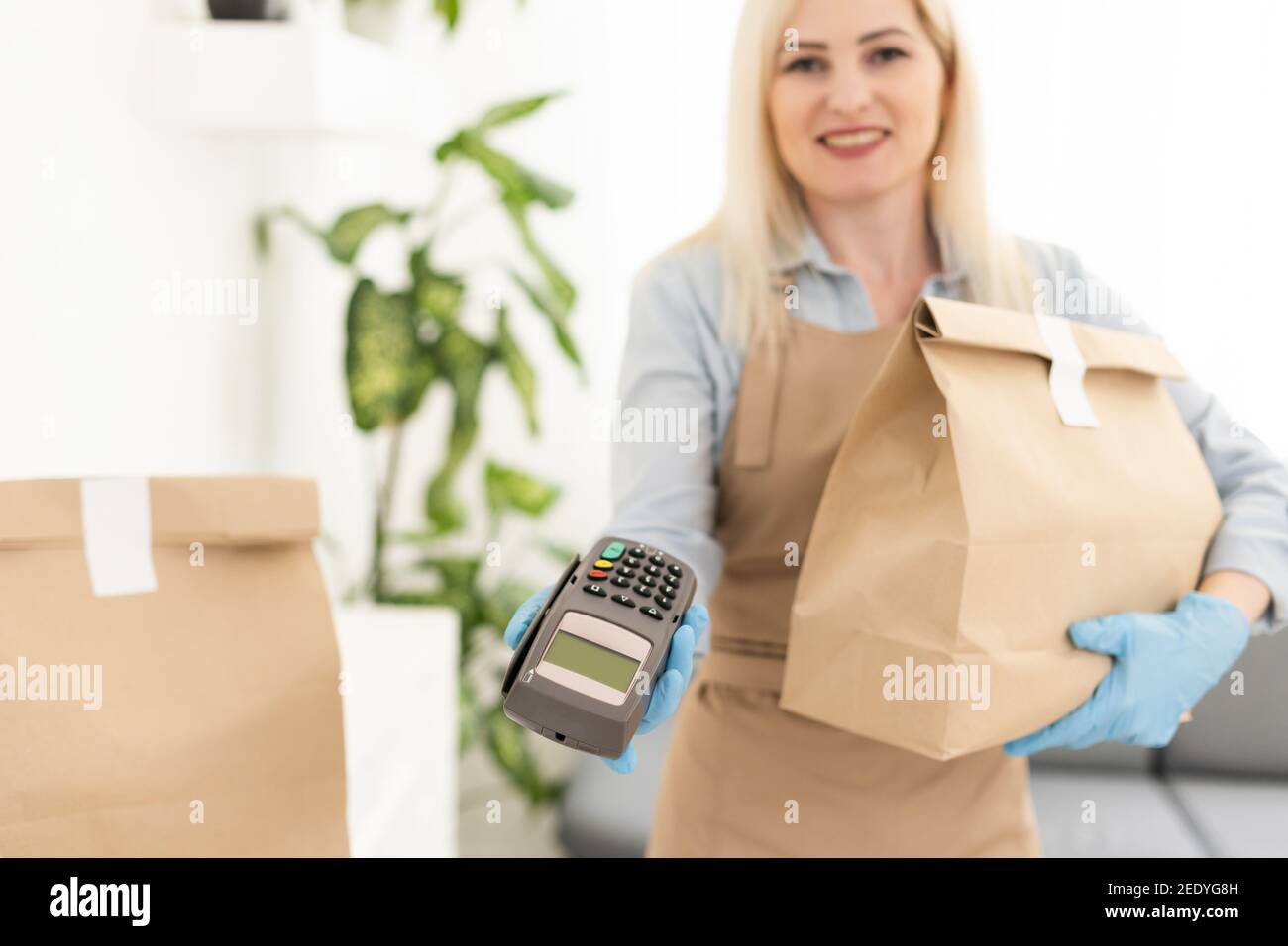 woman with pos terminal and delivery package Stock Photo - Alamy