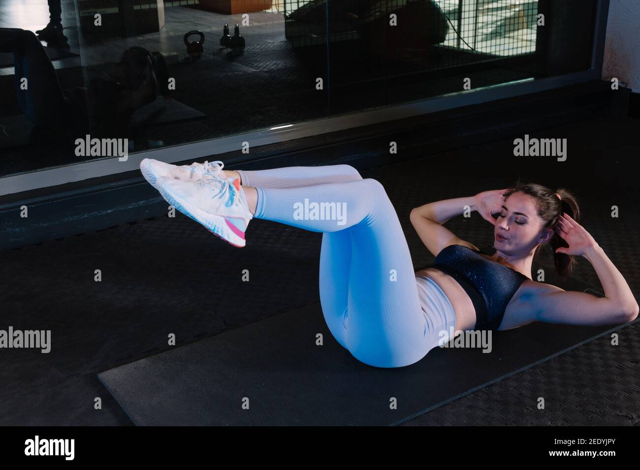 Beautiful young woman doing abs crunches in gym. Getting perfect body ...