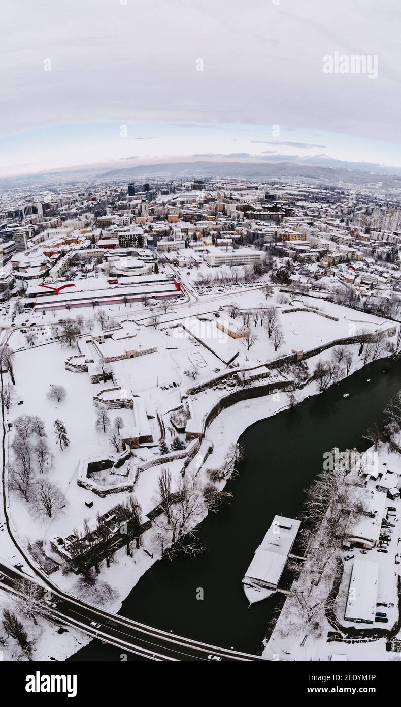 Bridge over a river with city buildings covered with snow in Banja Luka ...