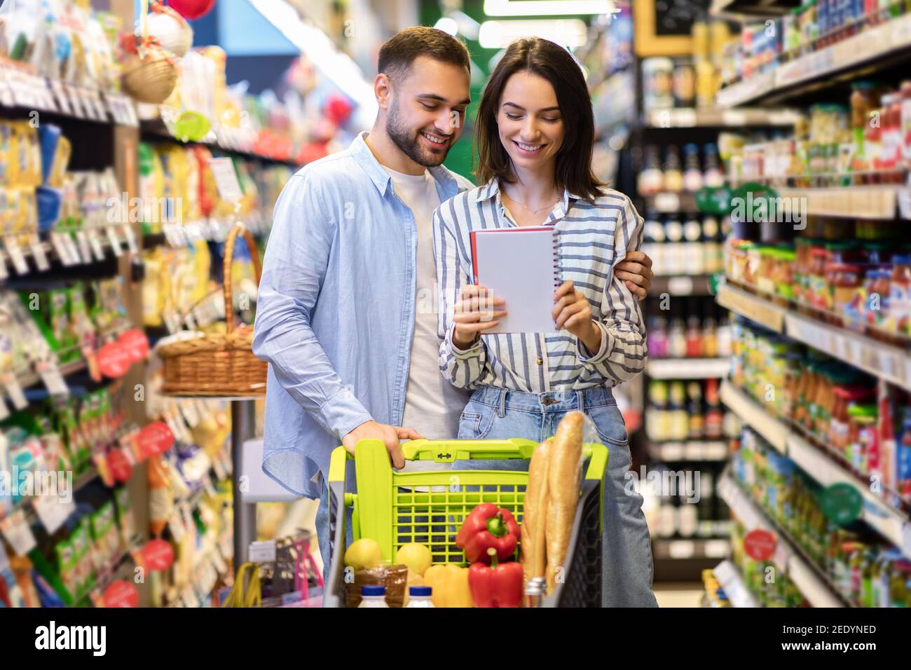 Young couple reading shopping list in supermarket Stock Photo - Alamy