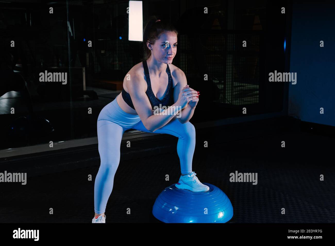 Slim, bodybuilder girl, does the exercises with Ball Balance in the gym ...