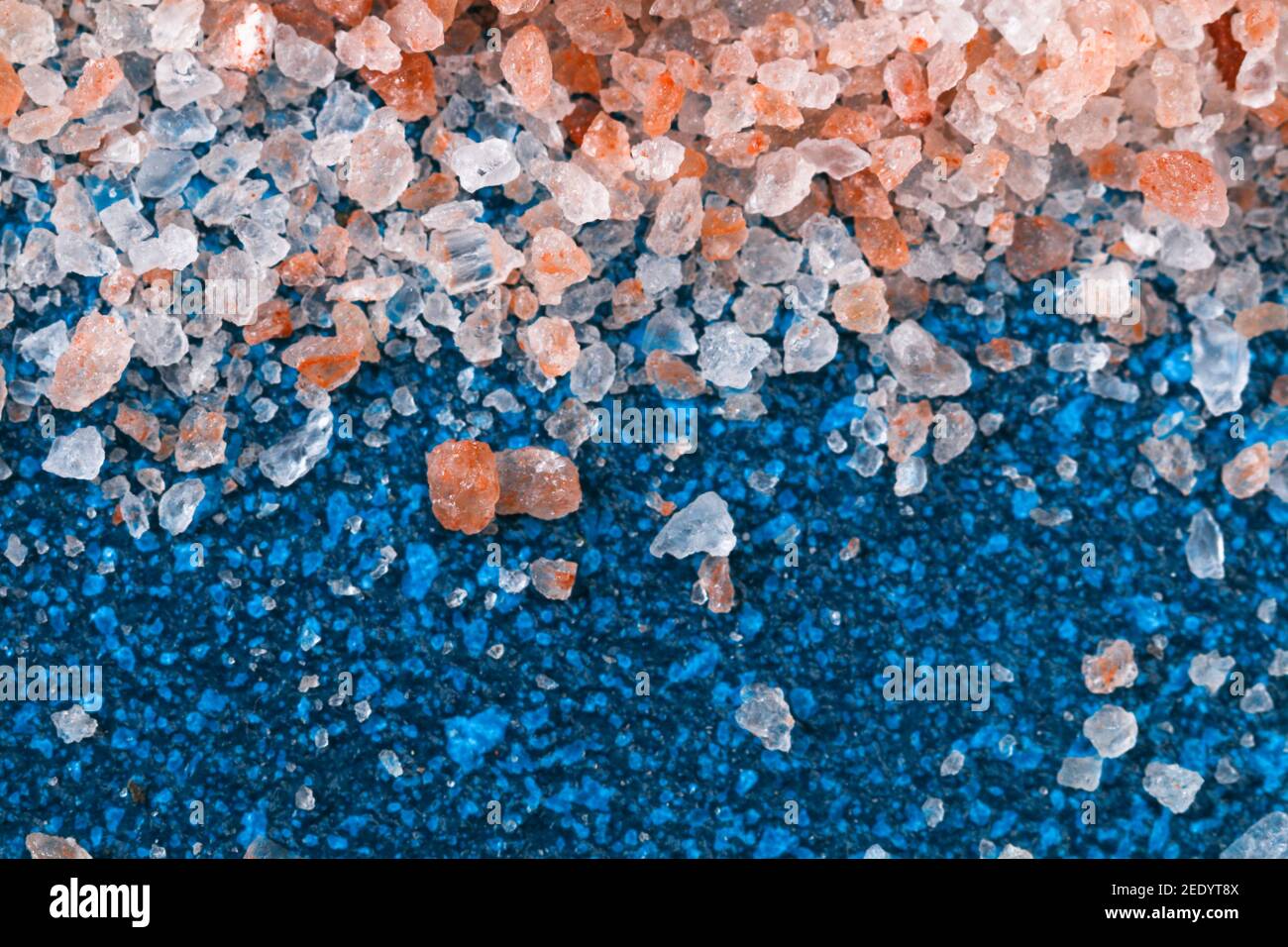 Pink coarse salt crystals on a blue table. Himalaya salt. Background ...