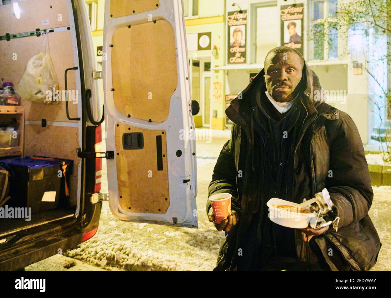 Berlin, Germany. 12th Feb, 2021. A homeless man stands at the cold bus ...