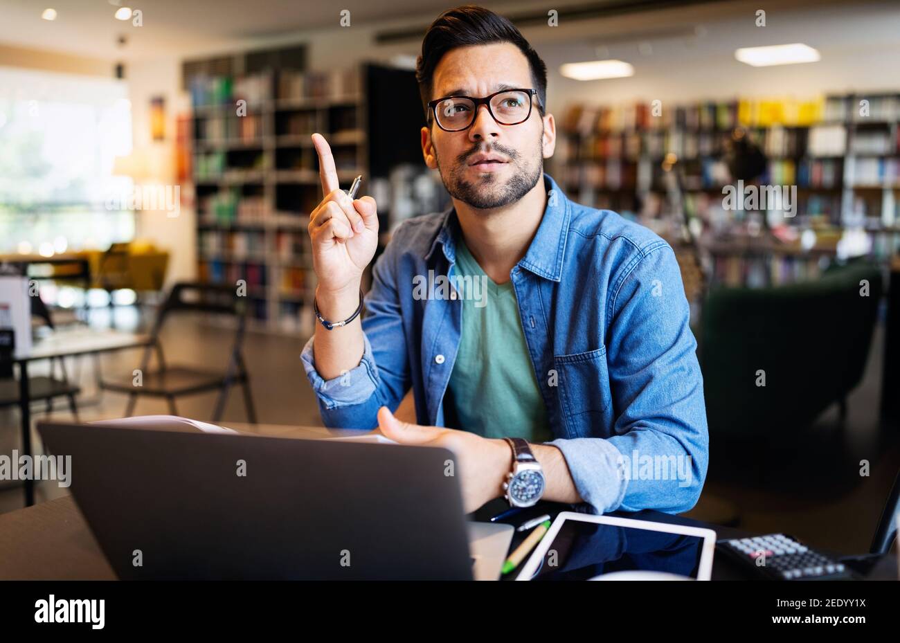 Smiling male student working and studying in a library Stock Photo - Alamy