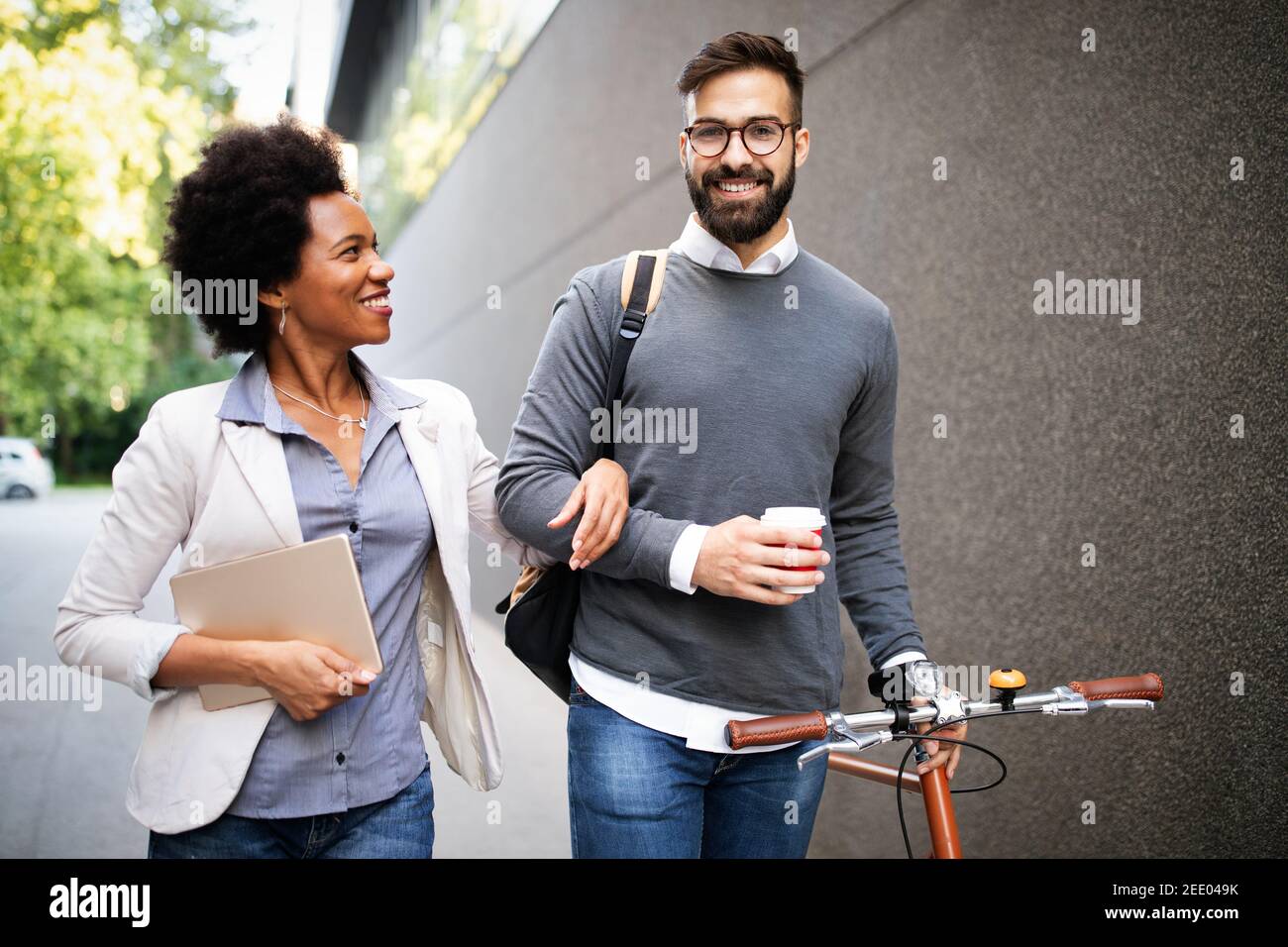 Cheerful people having fun, talking with electronic tablet in city ...