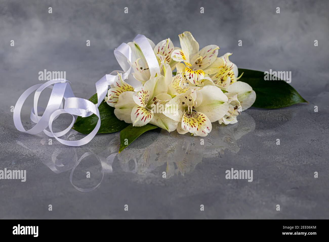 A bouquet of wild orchids on a light background decorated with ribbons ...