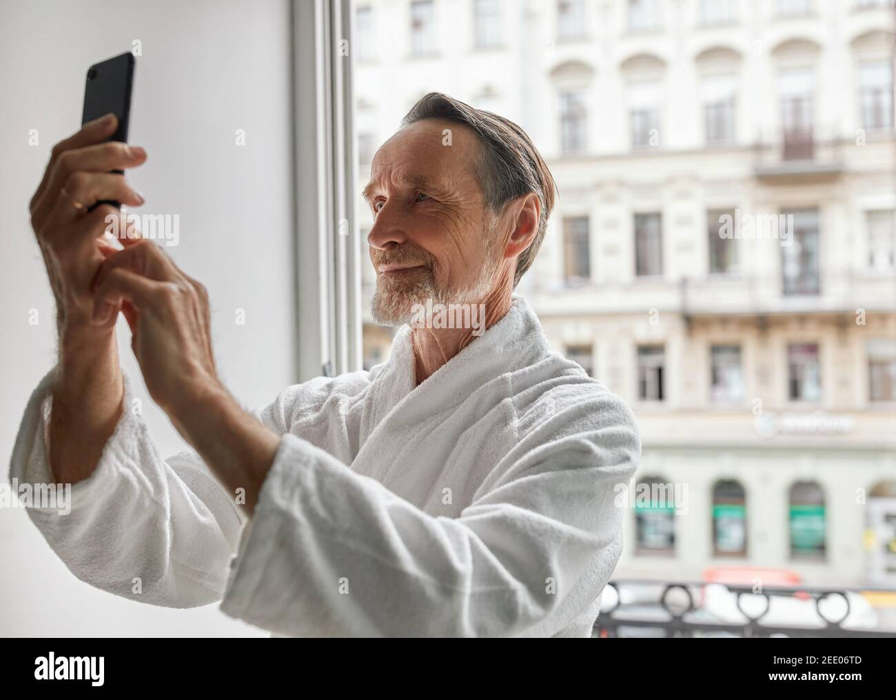 Handsome senior man taking a picture with a smartphone Stock Photo - Alamy