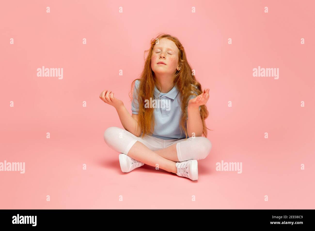Balanced, calming down. Happy, smiley redhair girl isolated on pink ...