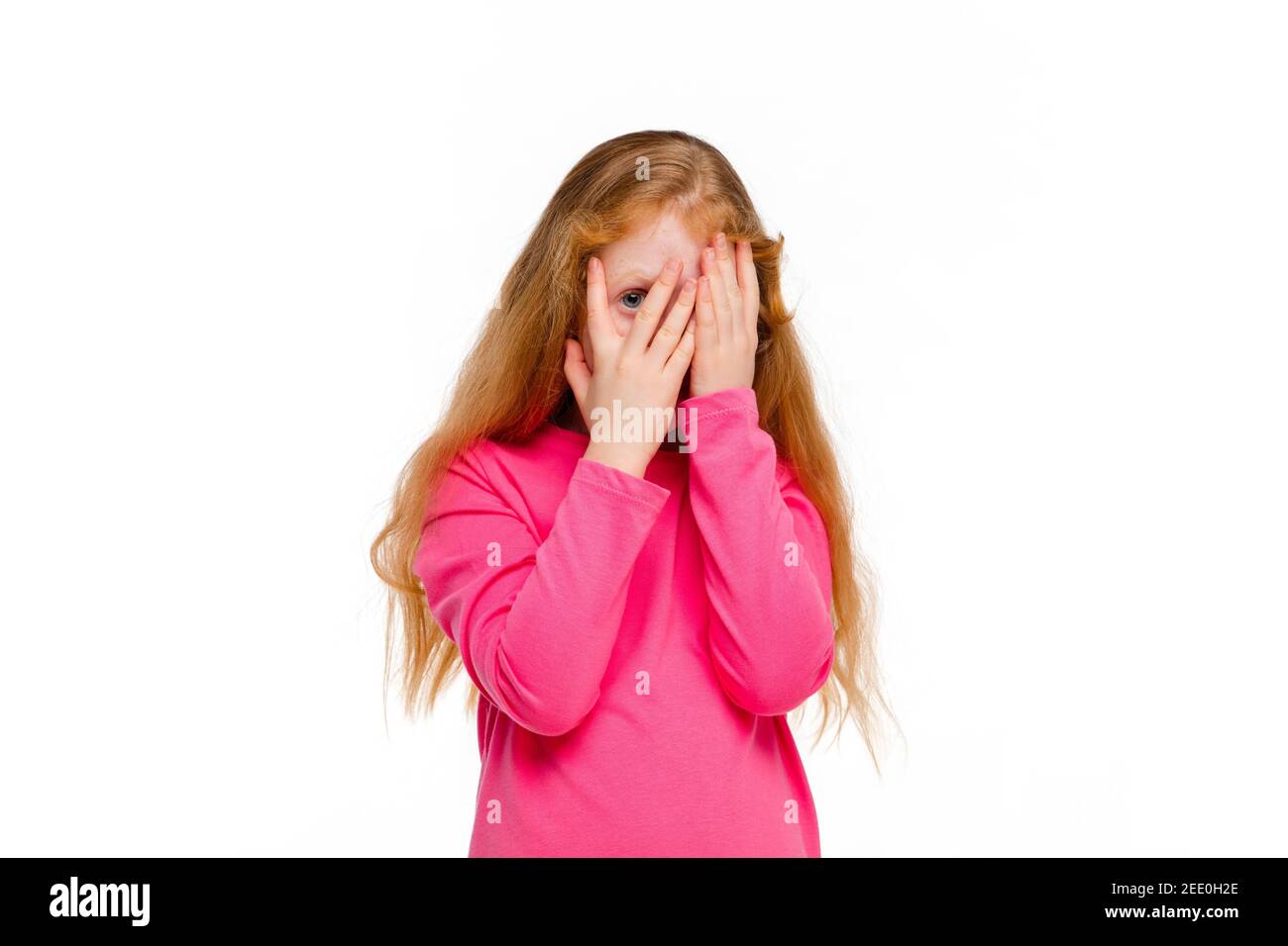 Frightened hiding face. Happy, smiley redhair girl isolated on white ...